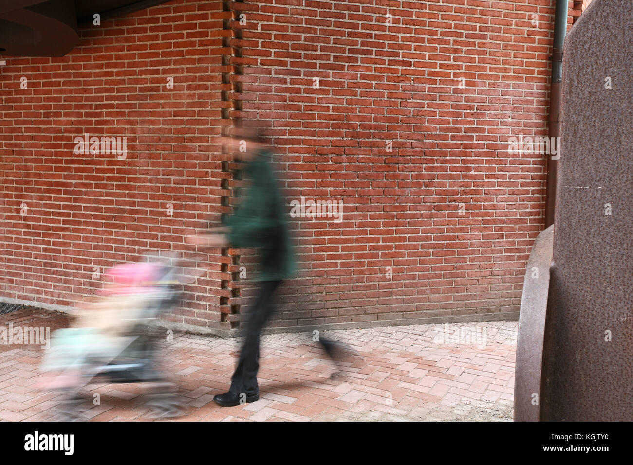People passing by a brick wall Stock Photo - Alamy