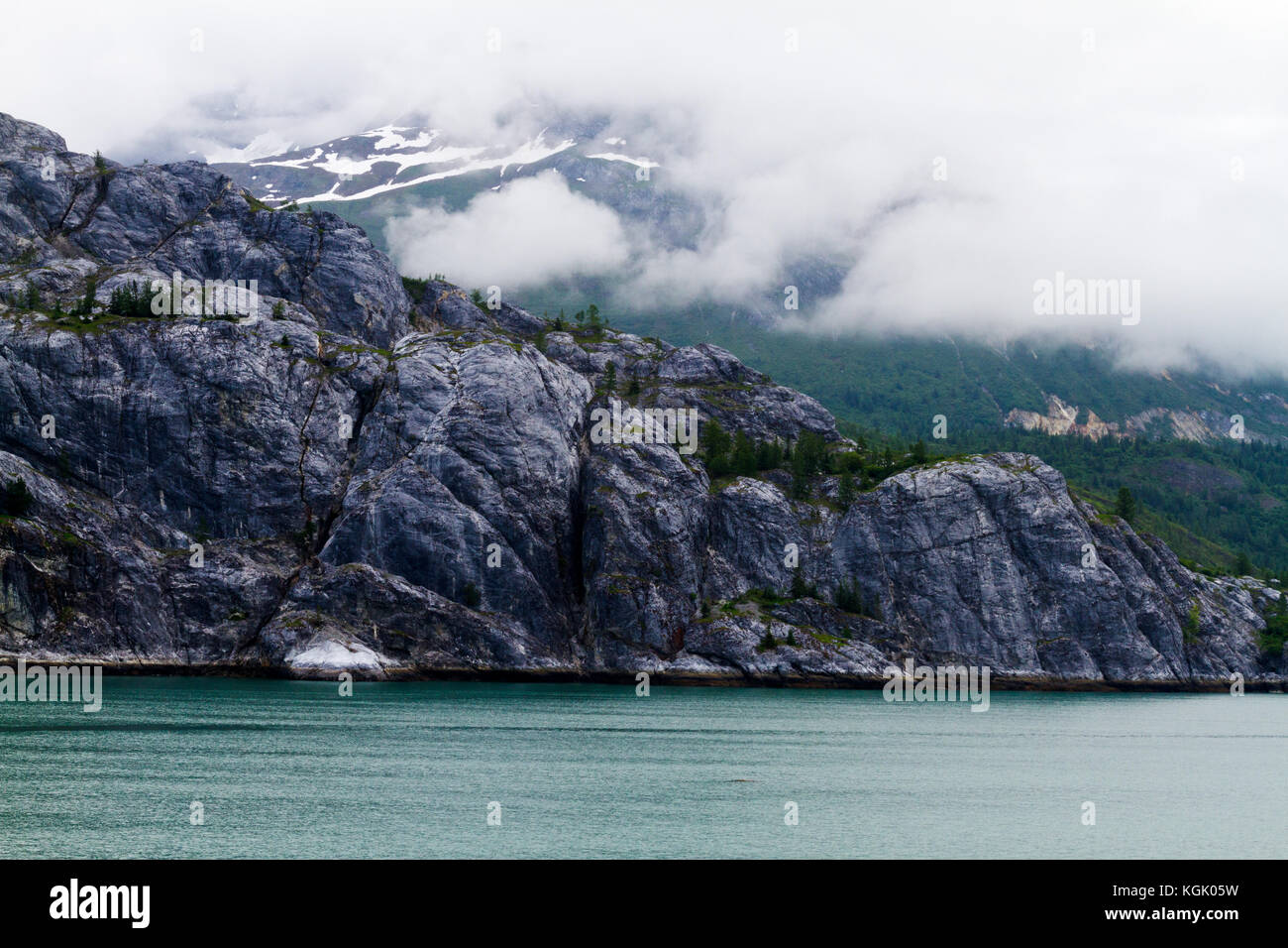 A dramatic view of rugged cliffs on the Alaskan coast near Glacier Bay ...