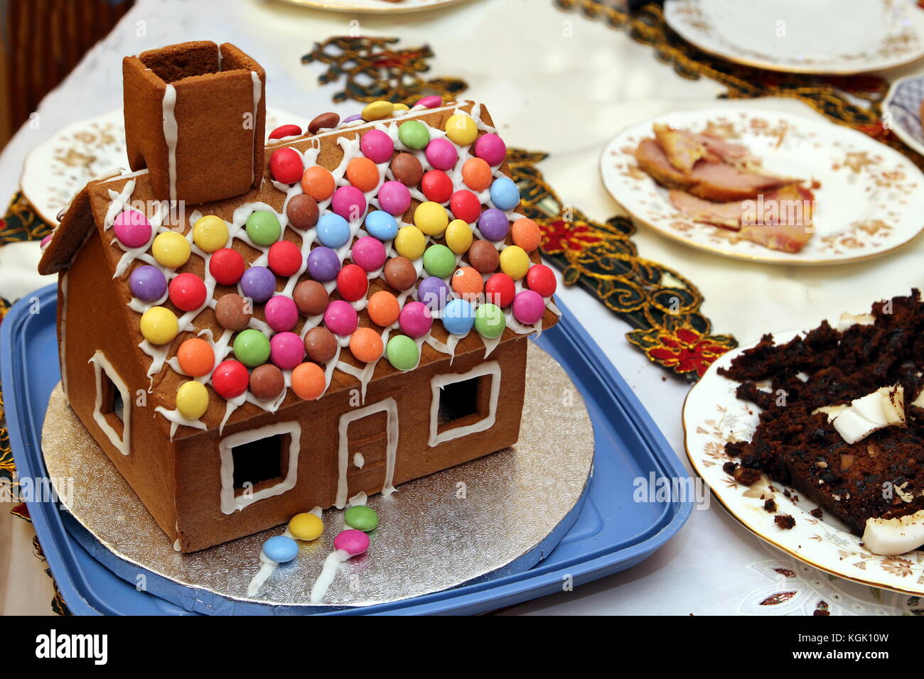 Traditional festive gingerbread house on a table with the remains of ...