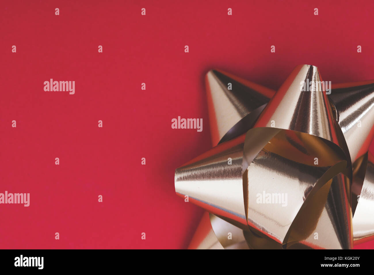 Metallic gift bow on a red background Stock Photo - Alamy