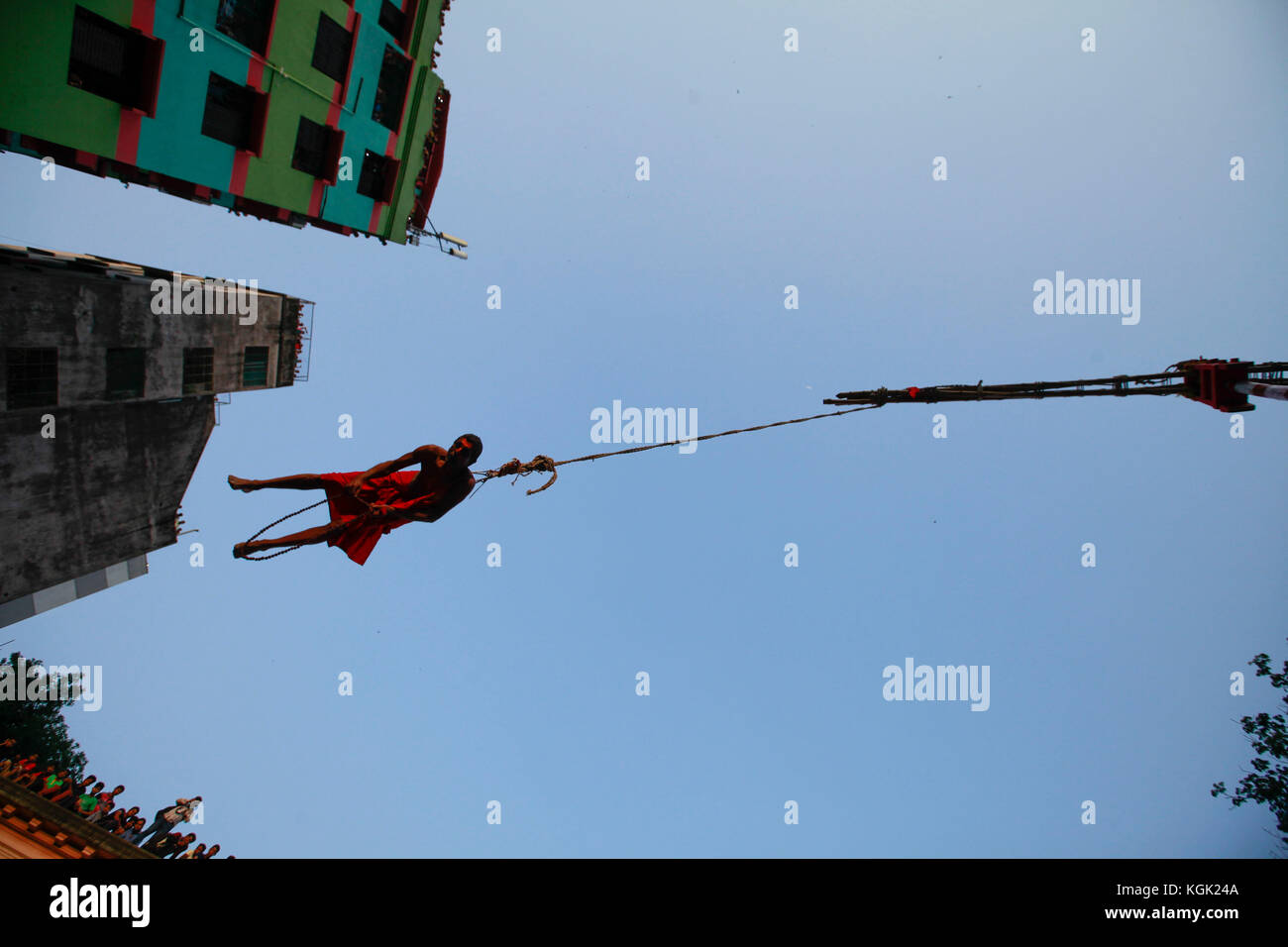 A Bangladeshi Hindu devotee hangs in a rope with hooks pierced in his ...