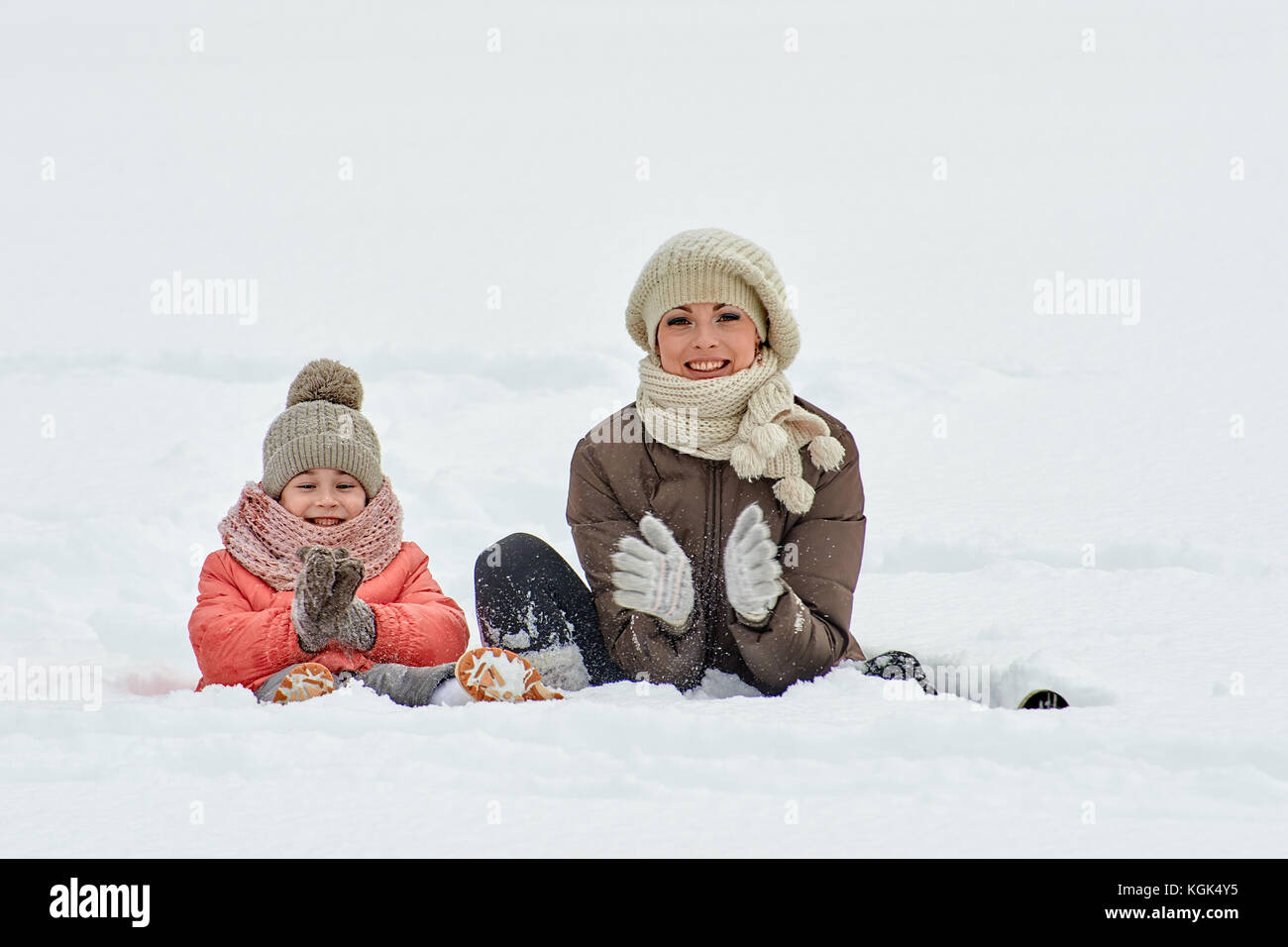 Mom with a little daughter spend a day off in the winter forest. They ...