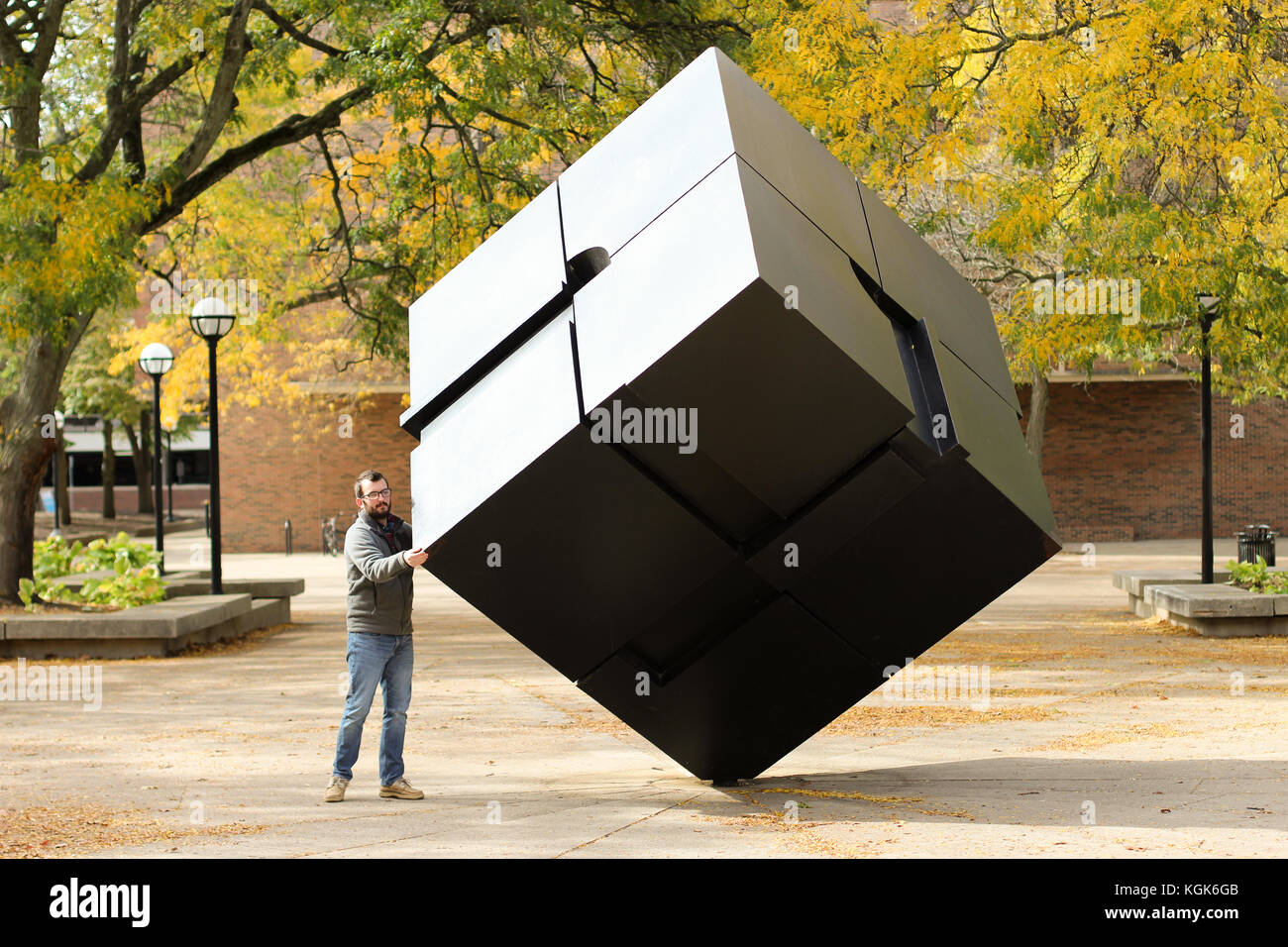 A man pushes a giant cube on the University of Michigan campus in Ann ...