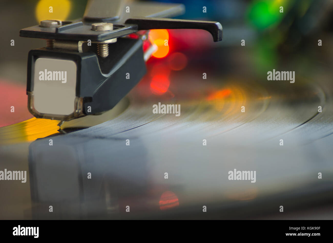 A turntable playing music vinyl record. Focused on tonearm, needle ...