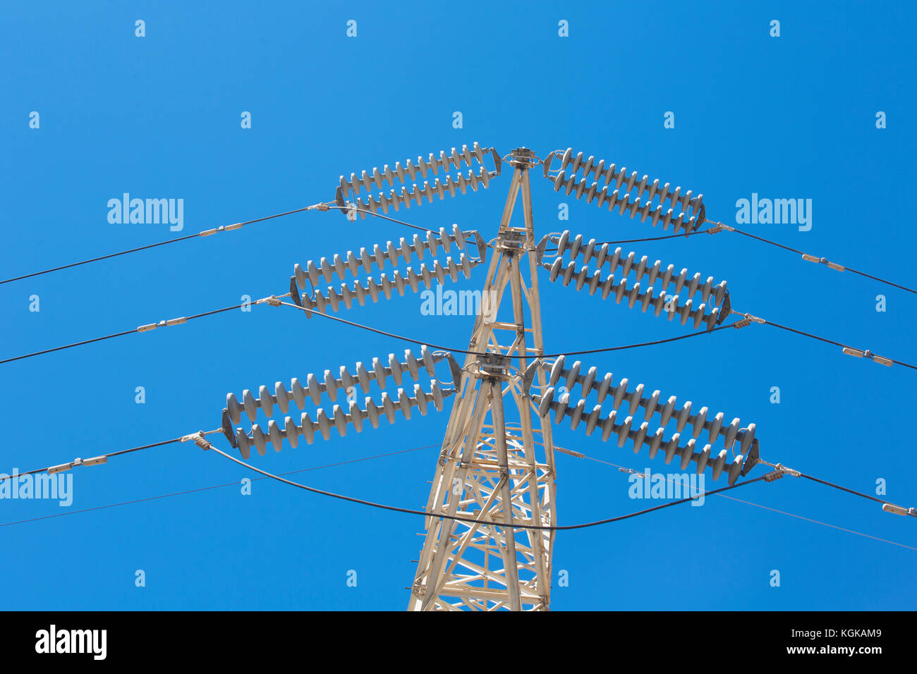The top of an electricity pylon agains a deep blue sky Stock Photo - Alamy