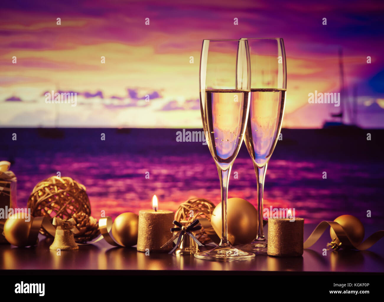 two champagne glasses against holiday lights and fireworks - new year ...