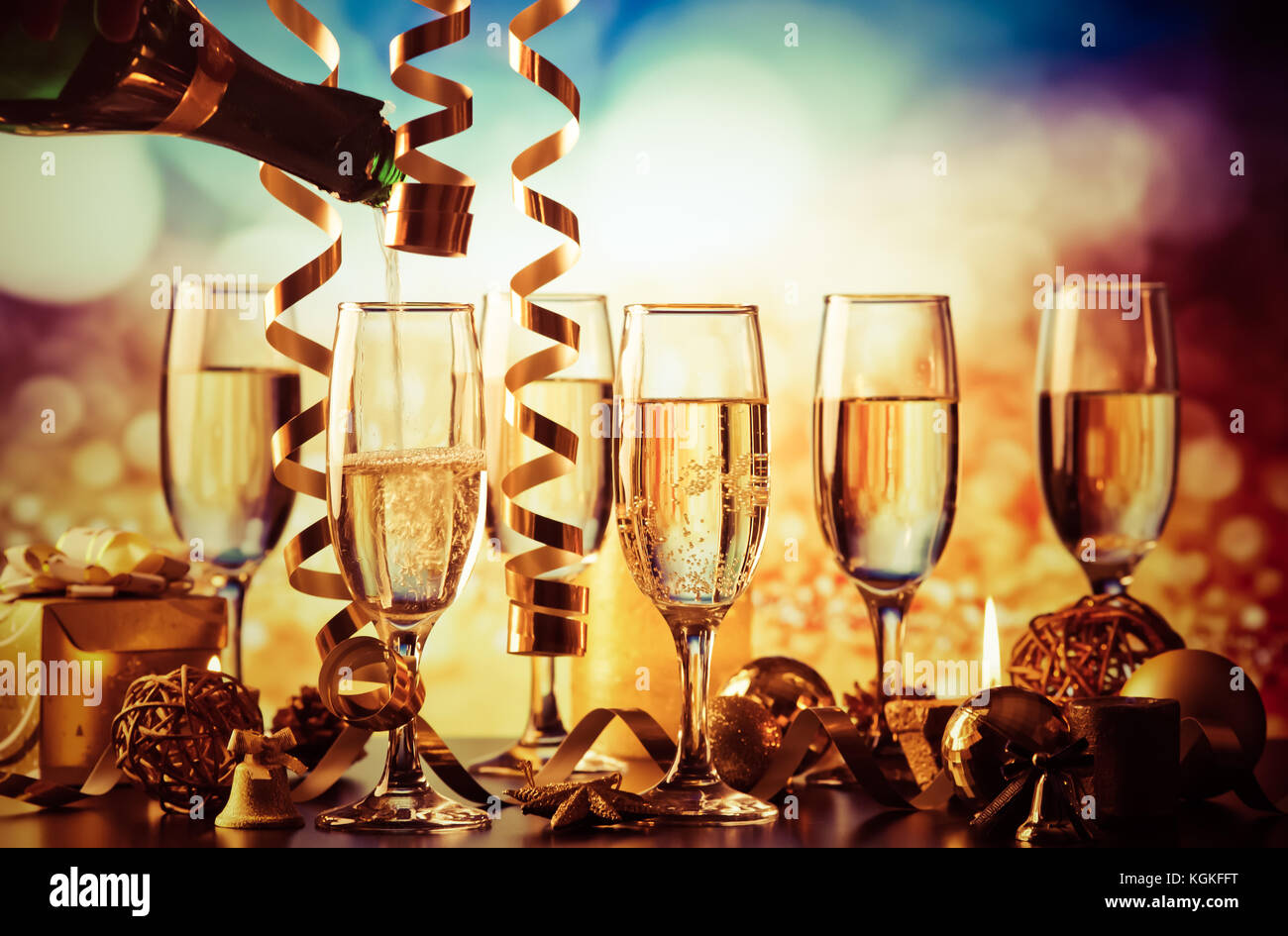 champagne glasses against holiday lights ready for New Year's eve party ...