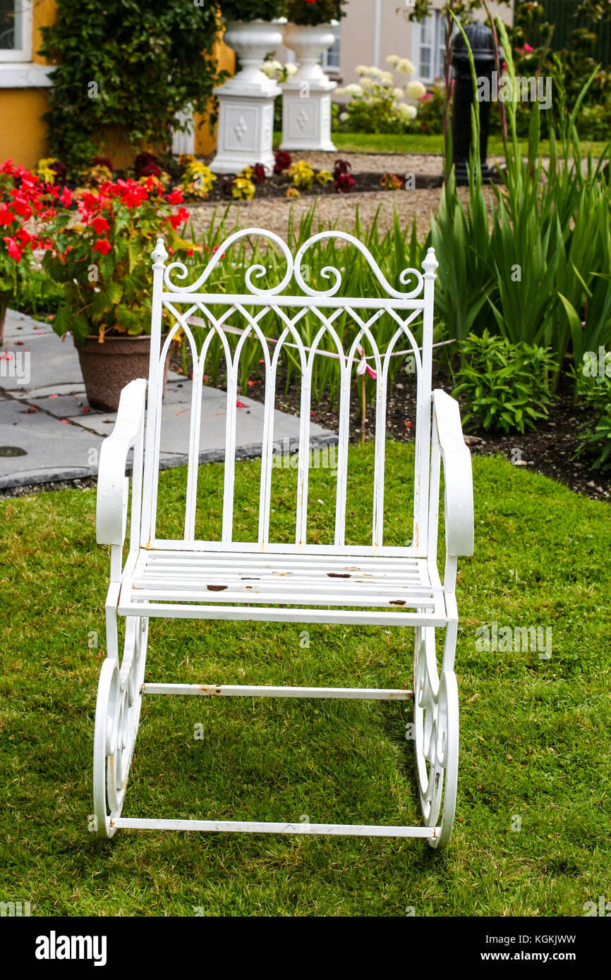 Single old fashioned ornate white wrought iron garden rocking chair in ...