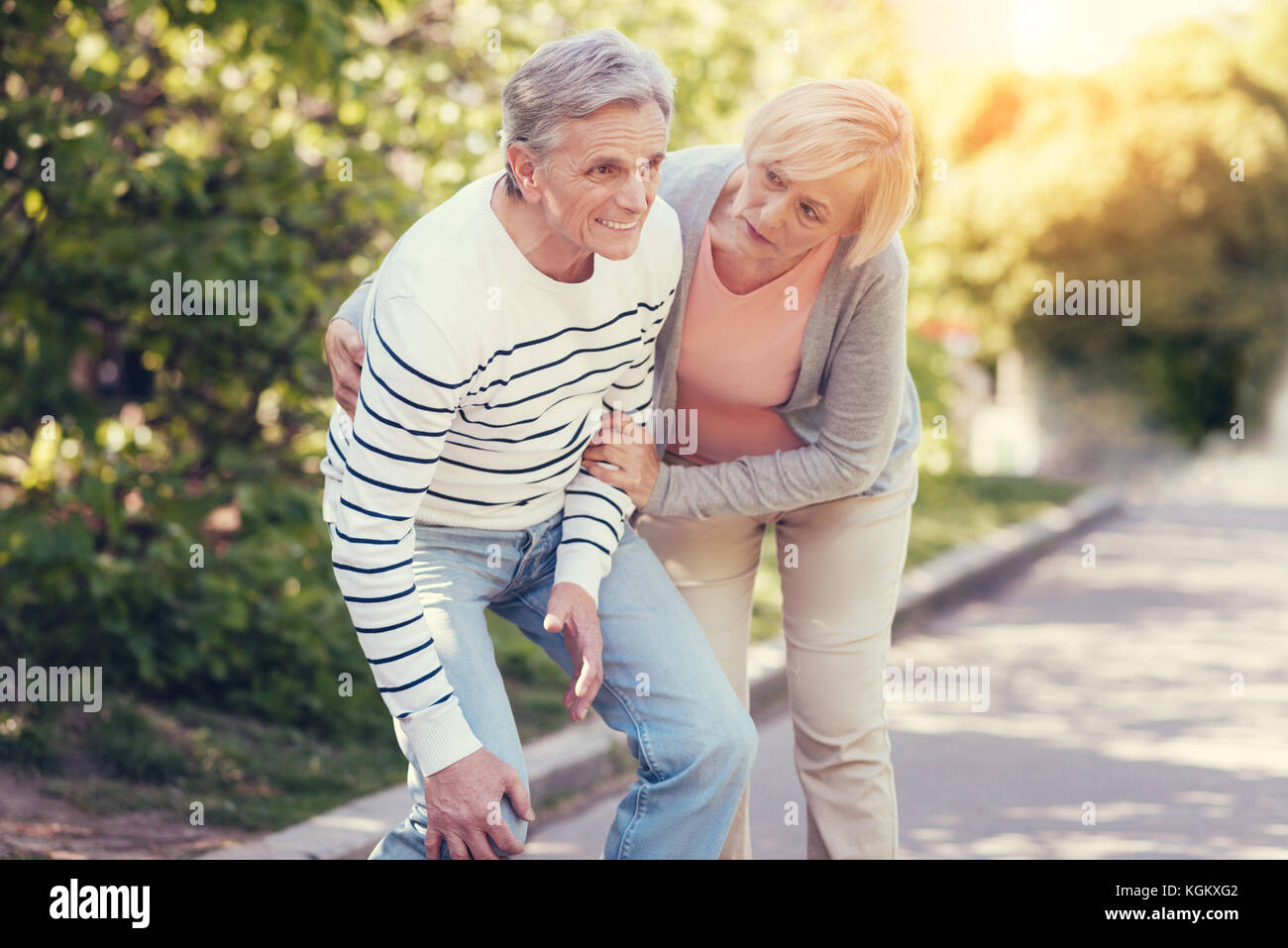 Nice caring woman helping her husband Stock Photo - Alamy