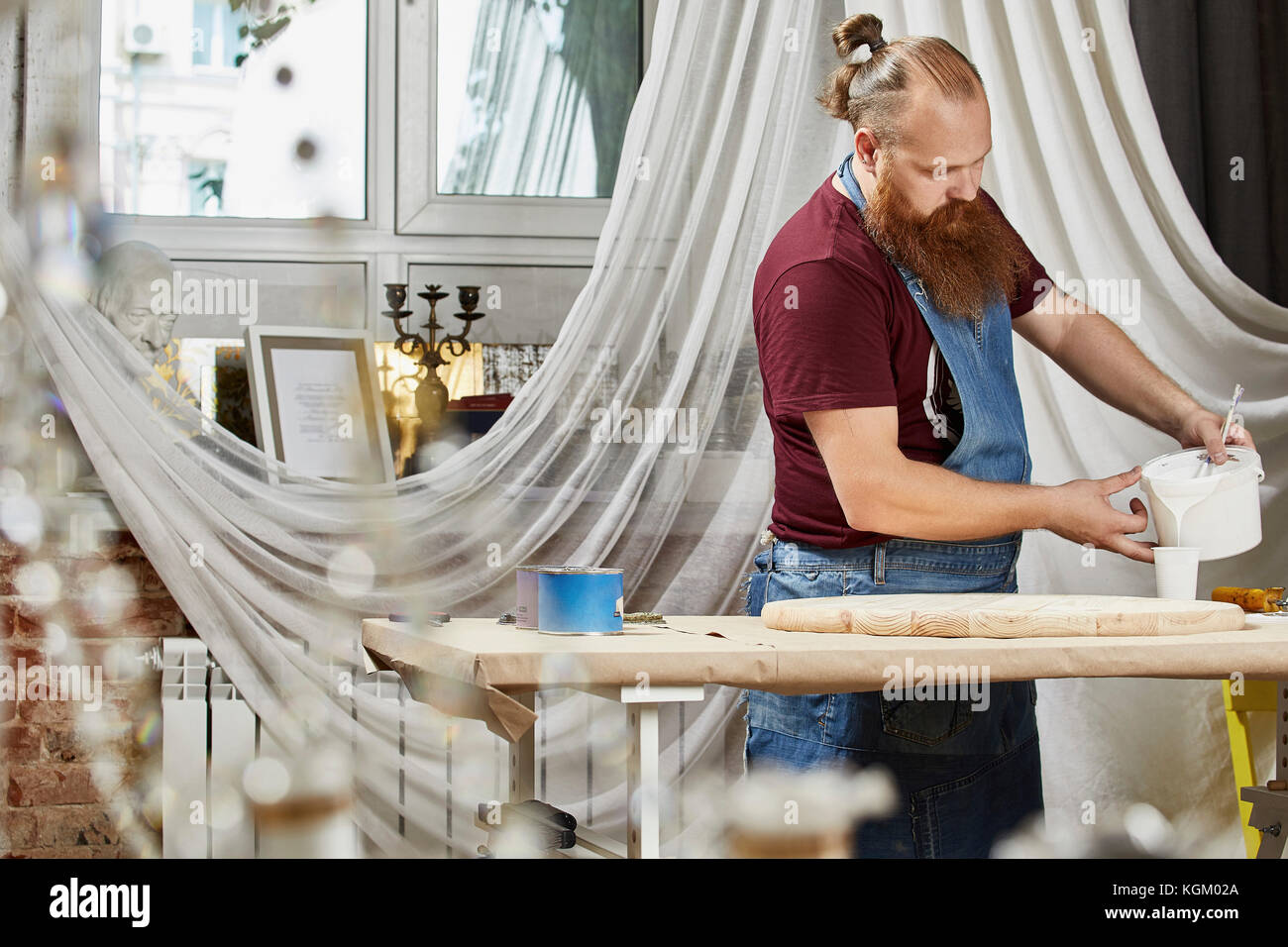 Man pouring paint in container on workbench at workshop Stock Photo - Alamy