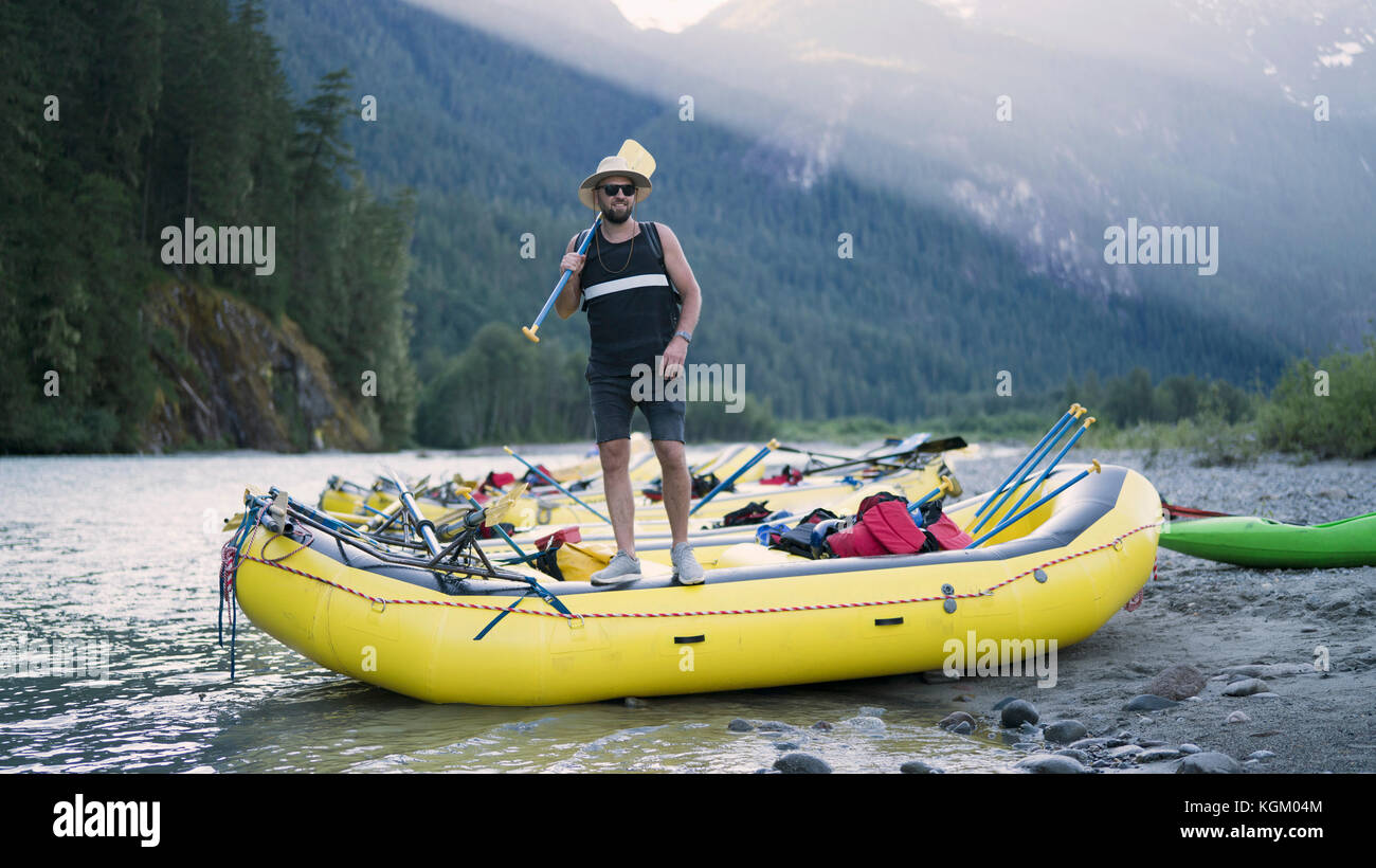 Man holding oar while standing on raft at riverbank, Squamish, British ...