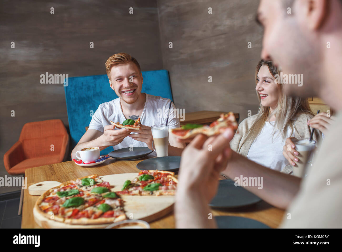 Friends enjoying pizza at restaurant Stock Photo - Alamy
