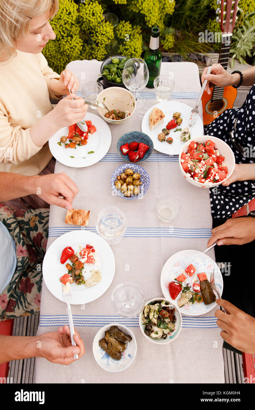 Directly above shot of male and female friends having lunch at outdoor ...