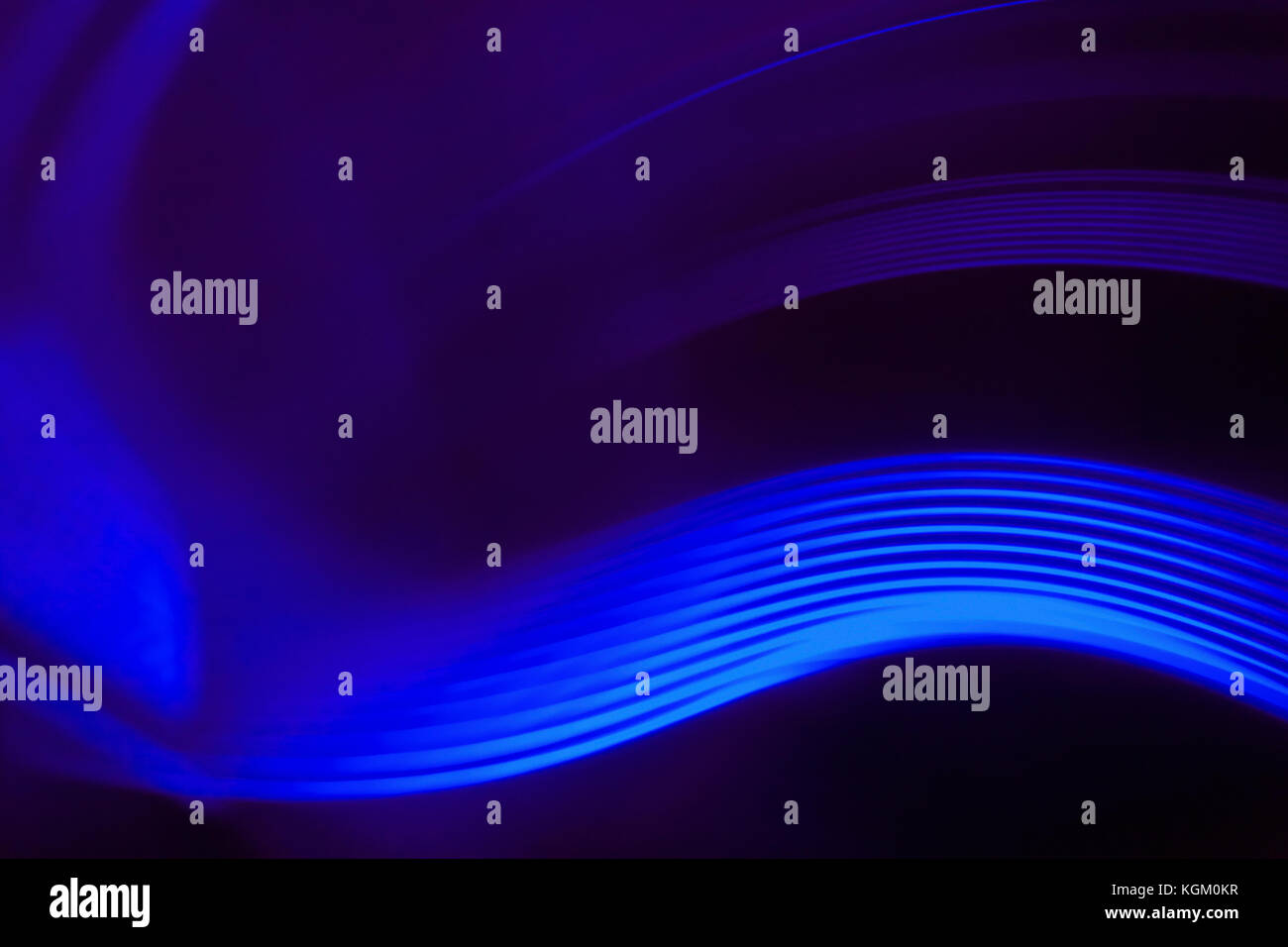 Close-up abstract image of vibrant blue light trails against black ...