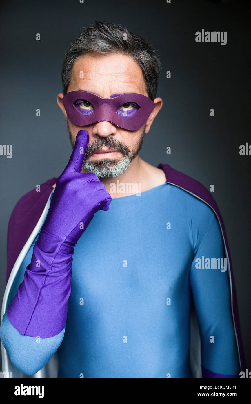 Portrait of confident superhero gesturing against gray background Stock ...