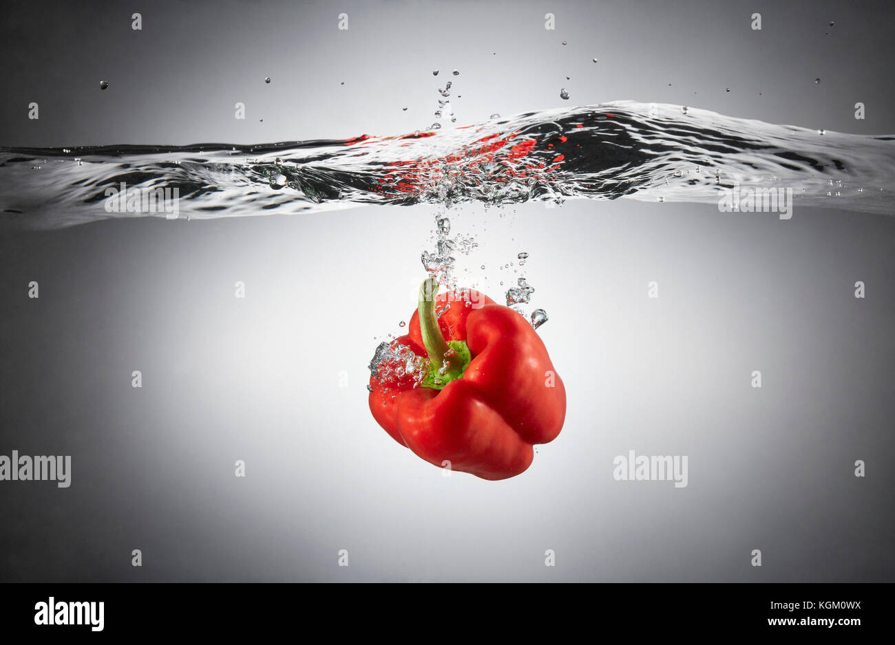 Close-up of red bell pepper in splashing water Stock Photo - Alamy