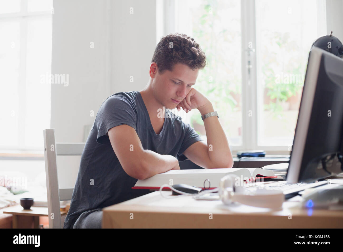 Young handsome university student studying at home Stock Photo - Alamy