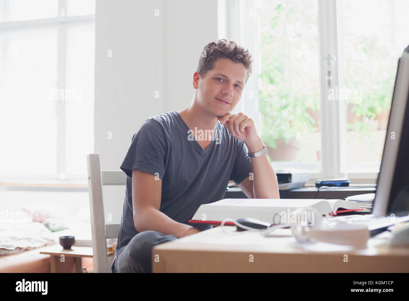 Portrait of handsome young male university student studying at home ... Portrait of handsome young male university student studying at home ...