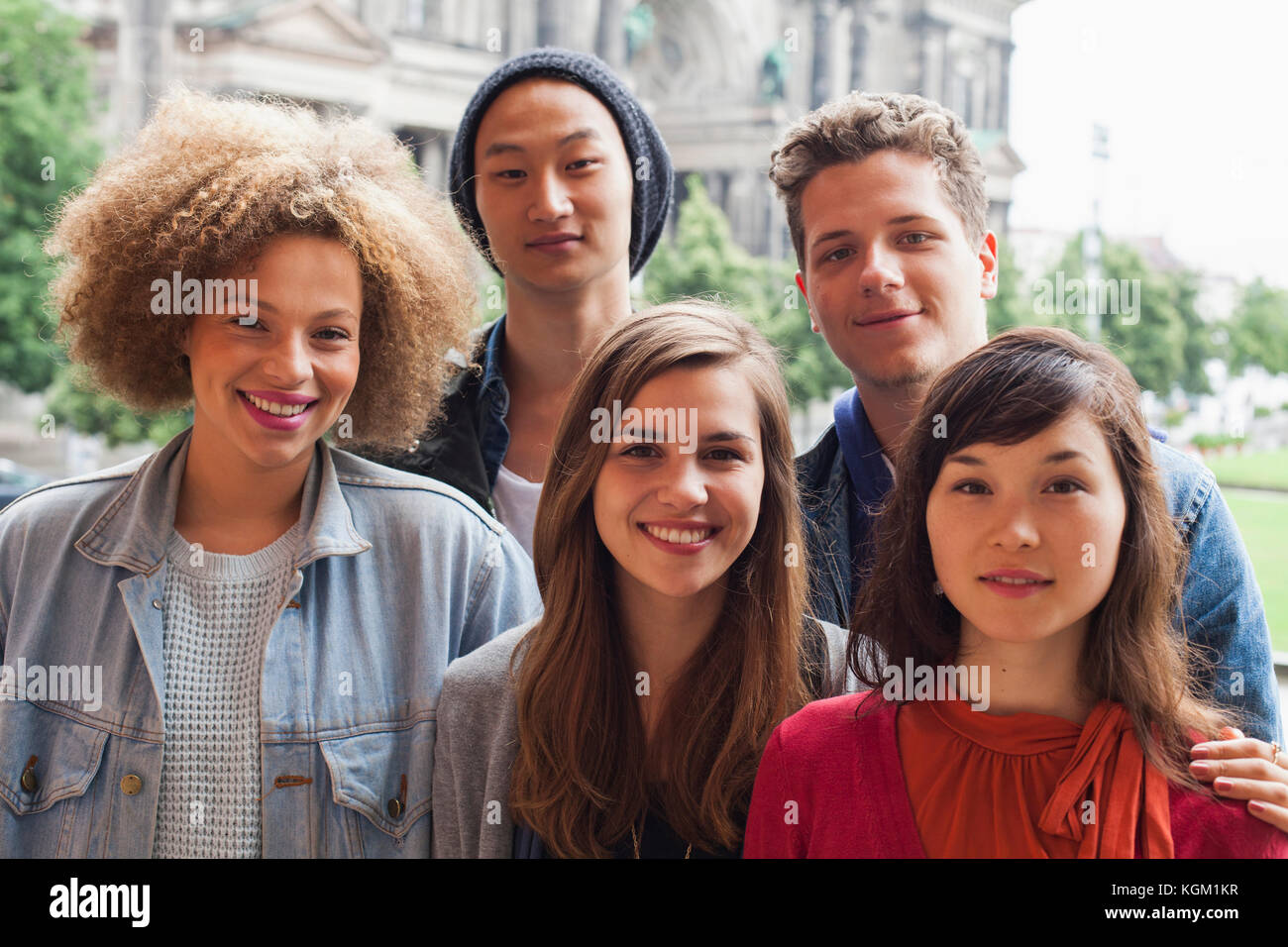 Portrait of smiling multi-ethnic friends standing against Berlin ...