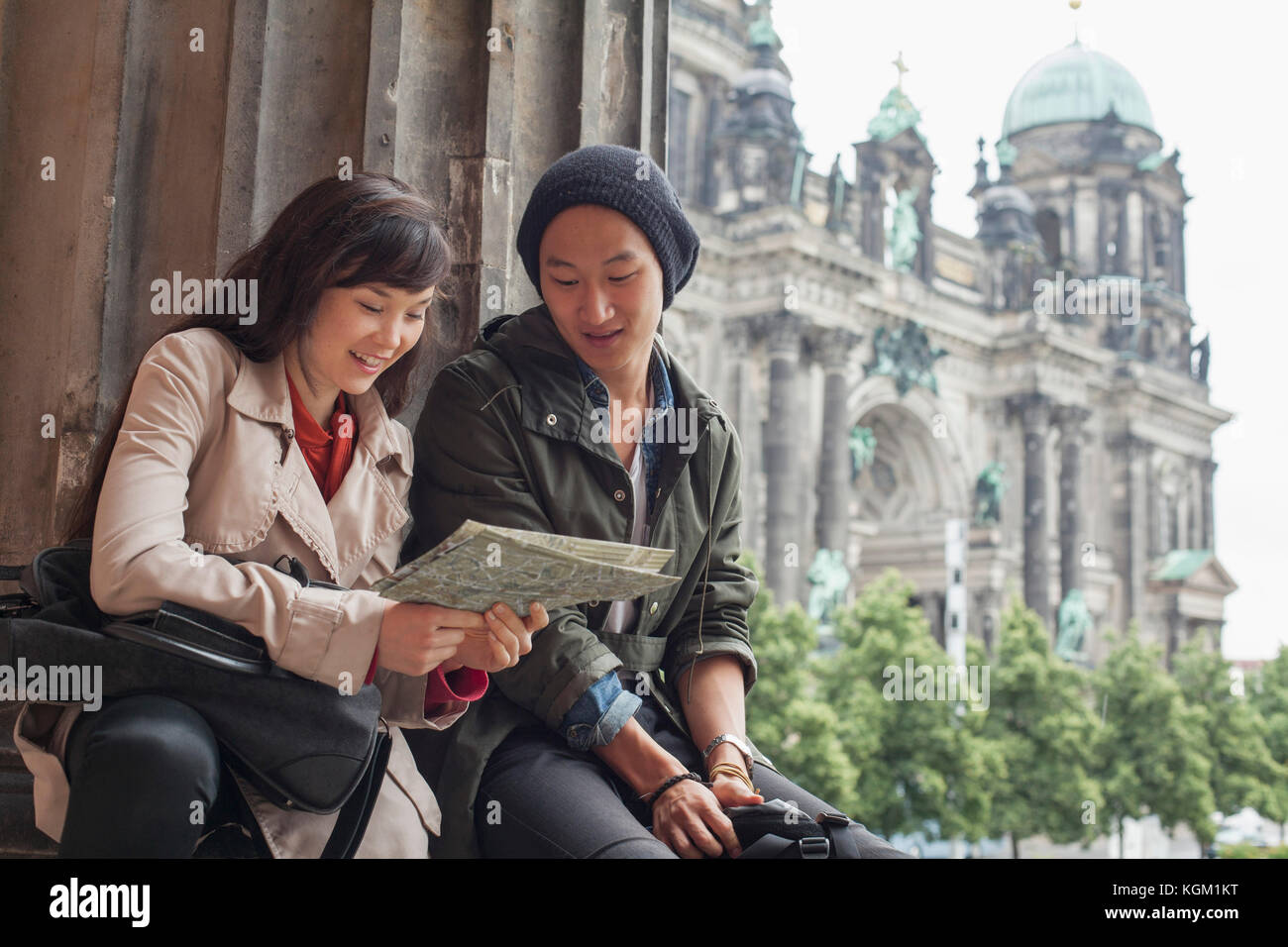 Low angle view of young friends reading map at Altes Museum against ...