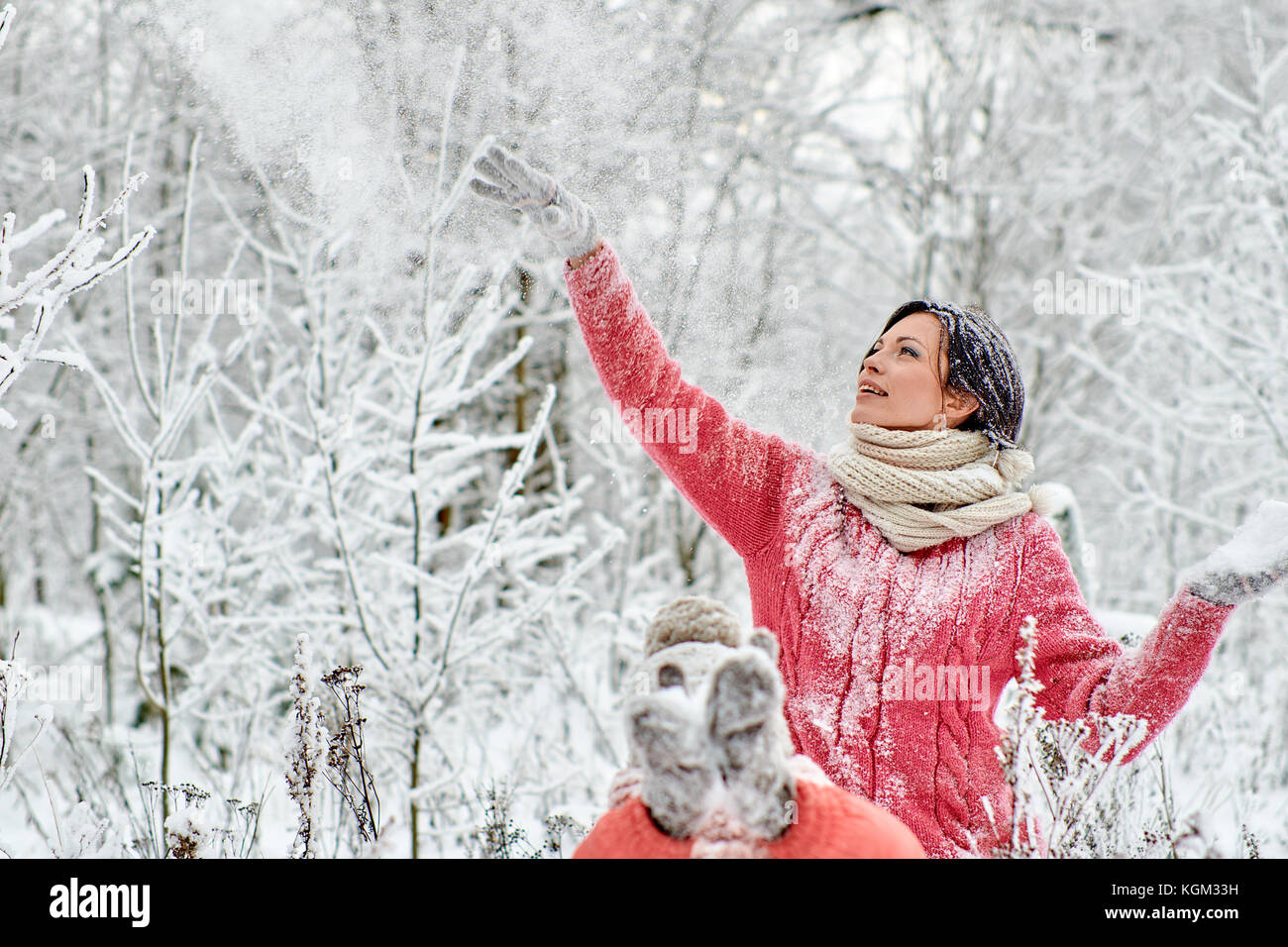 Mom with a little daughter spend a day off in the winter forest. They ...