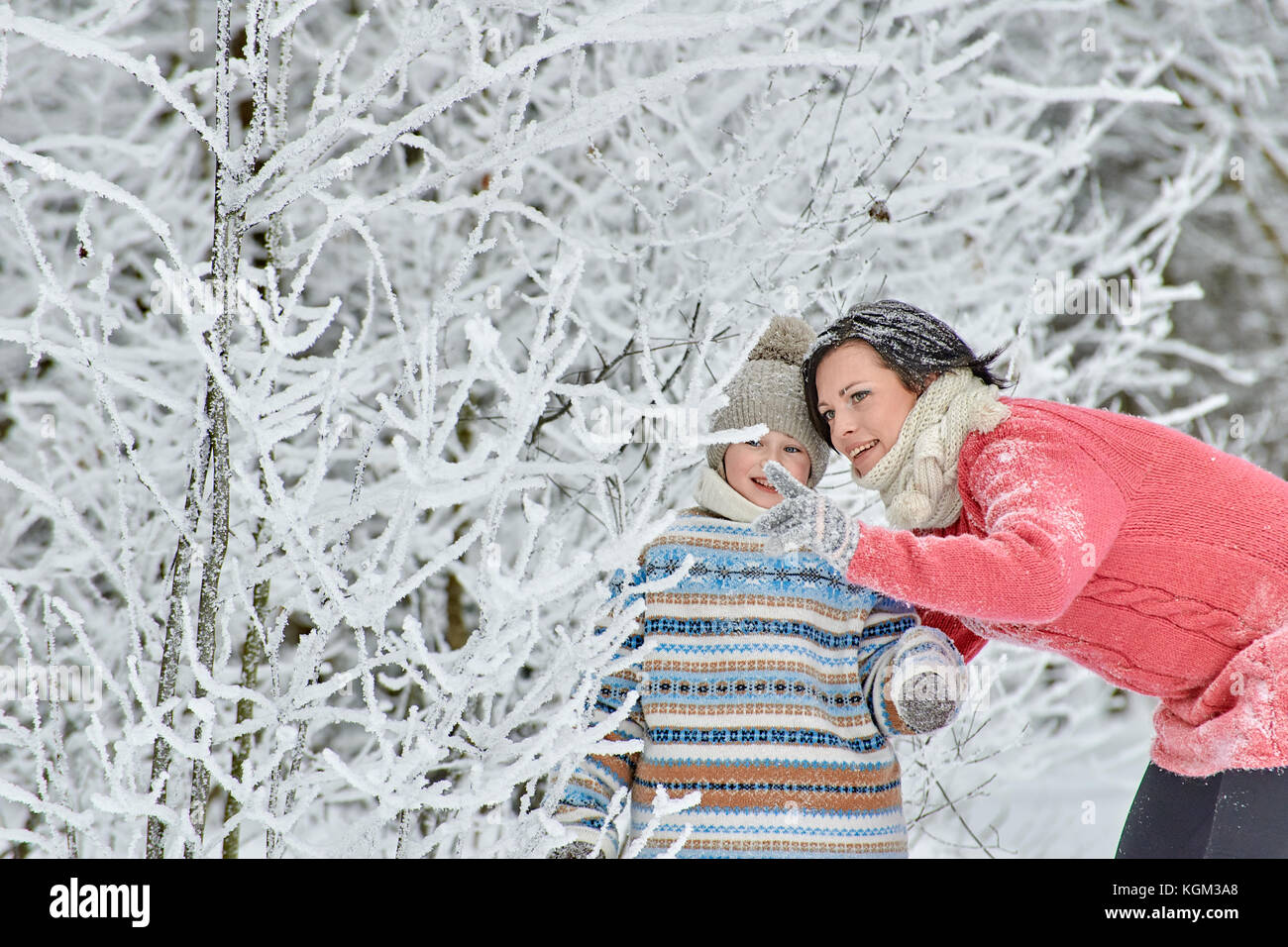 Mom with a little daughter spend a day off in the winter forest. They ...
