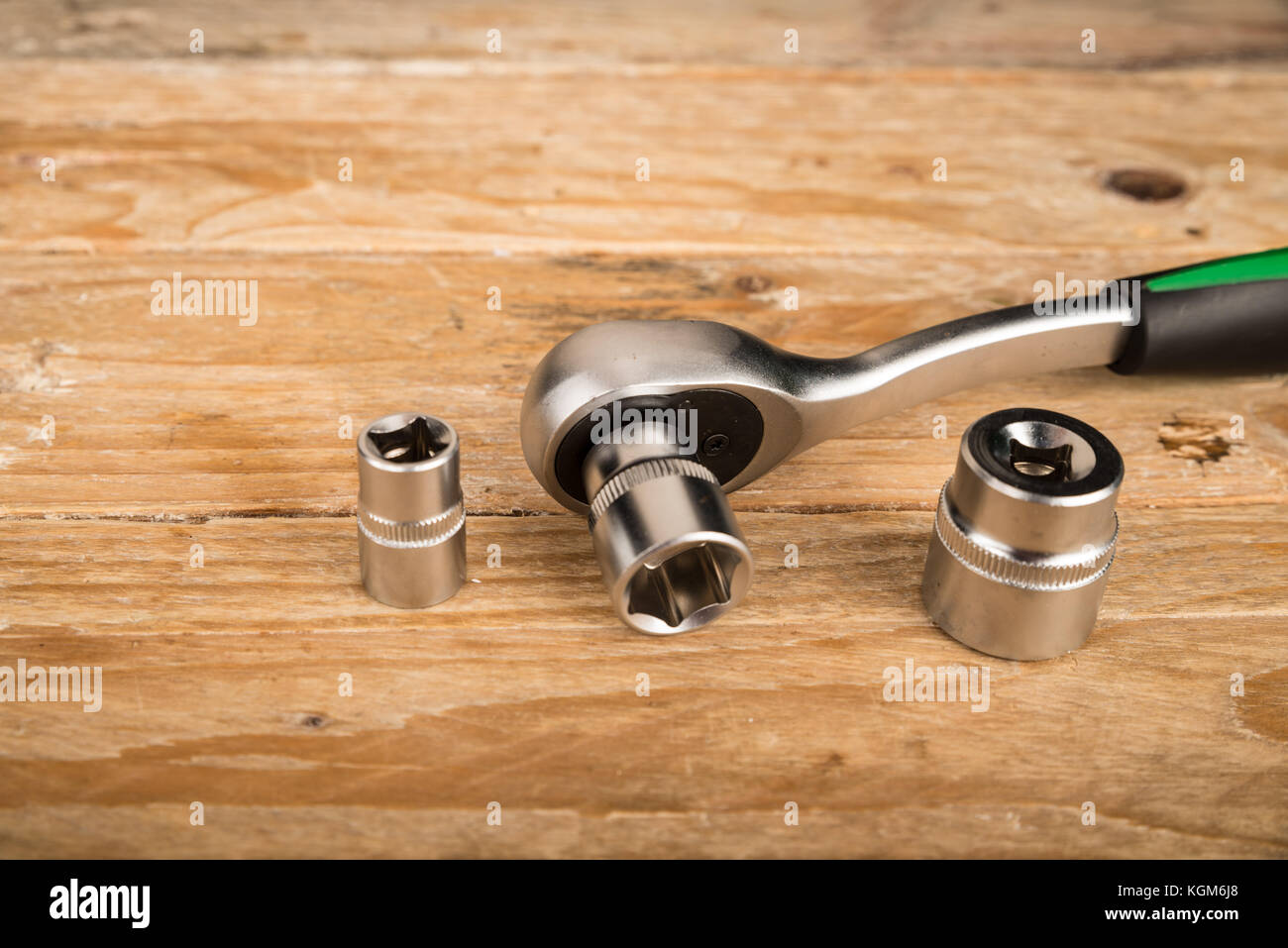 Ratchet wrench and different sized sockets on a wooden work bench Stock ...