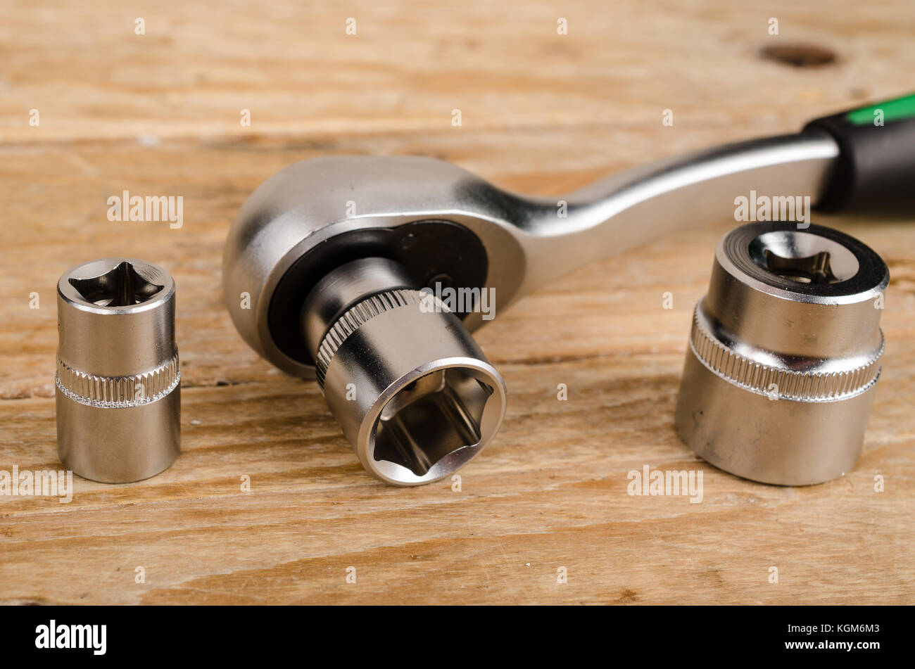 Ratchet wrench and different sized sockets on a wooden work bench Stock ...