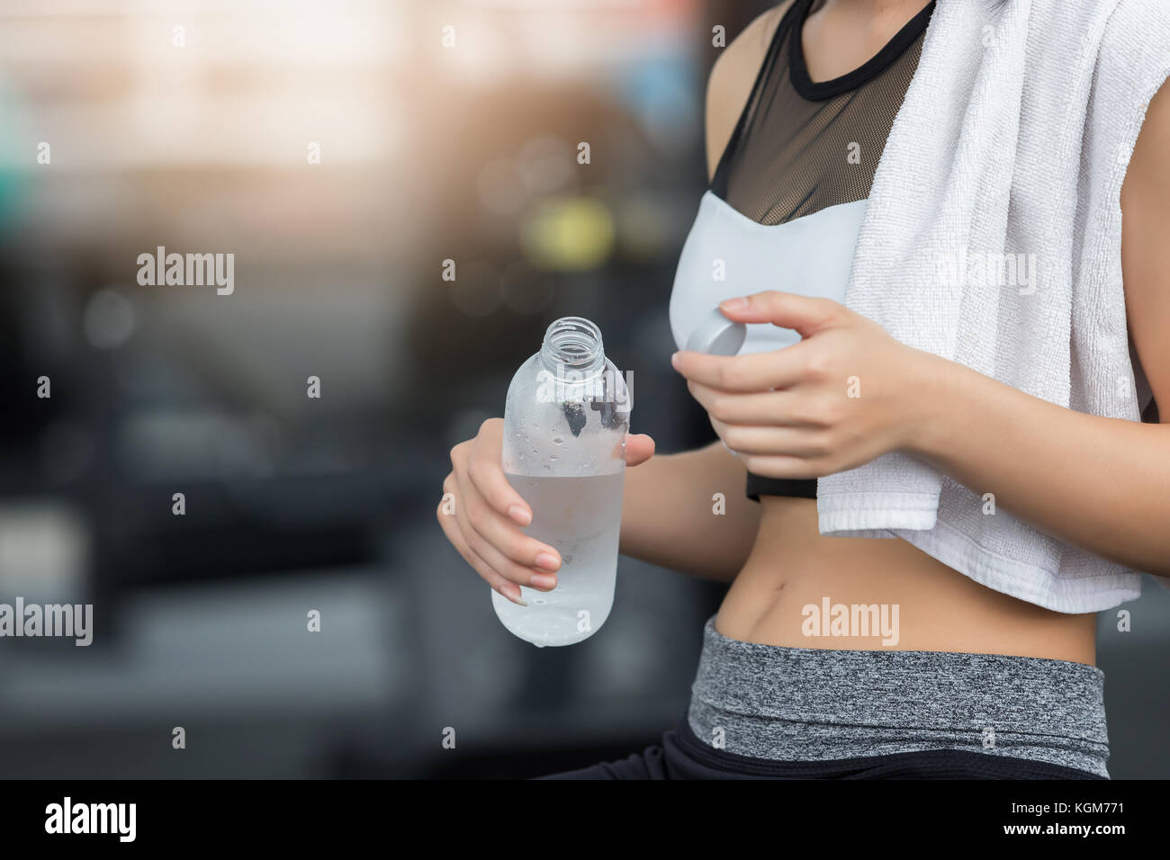 Fitness woman drinking water from bottle after work out in fitness ...