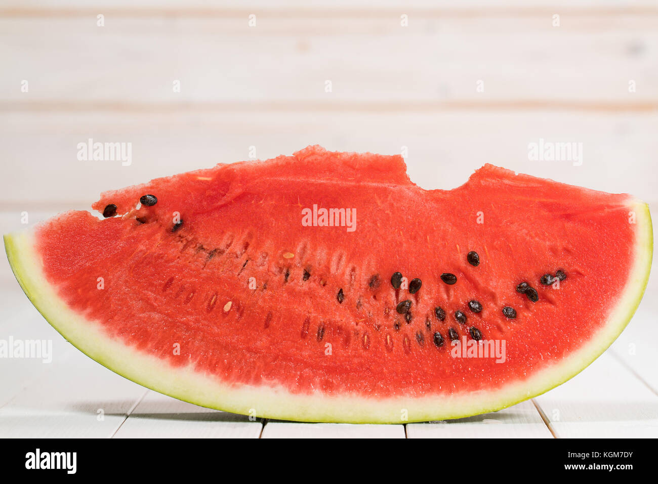 bitten slice of watermelon on a white background Stock Photo - Alamy