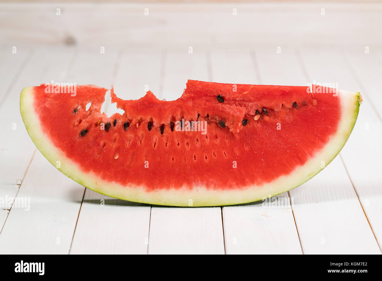 bitten slice of watermelon on a white background Stock Photo - Alamy