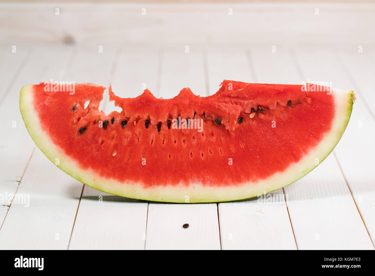 bitten slice of watermelon on a white background Stock Photo - Alamy