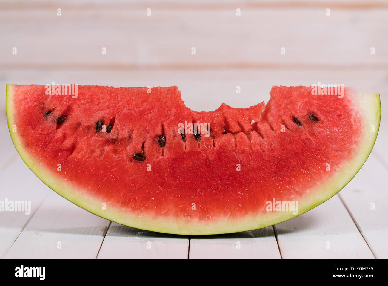 bitten slice of watermelon on a white background Stock Photo - Alamy