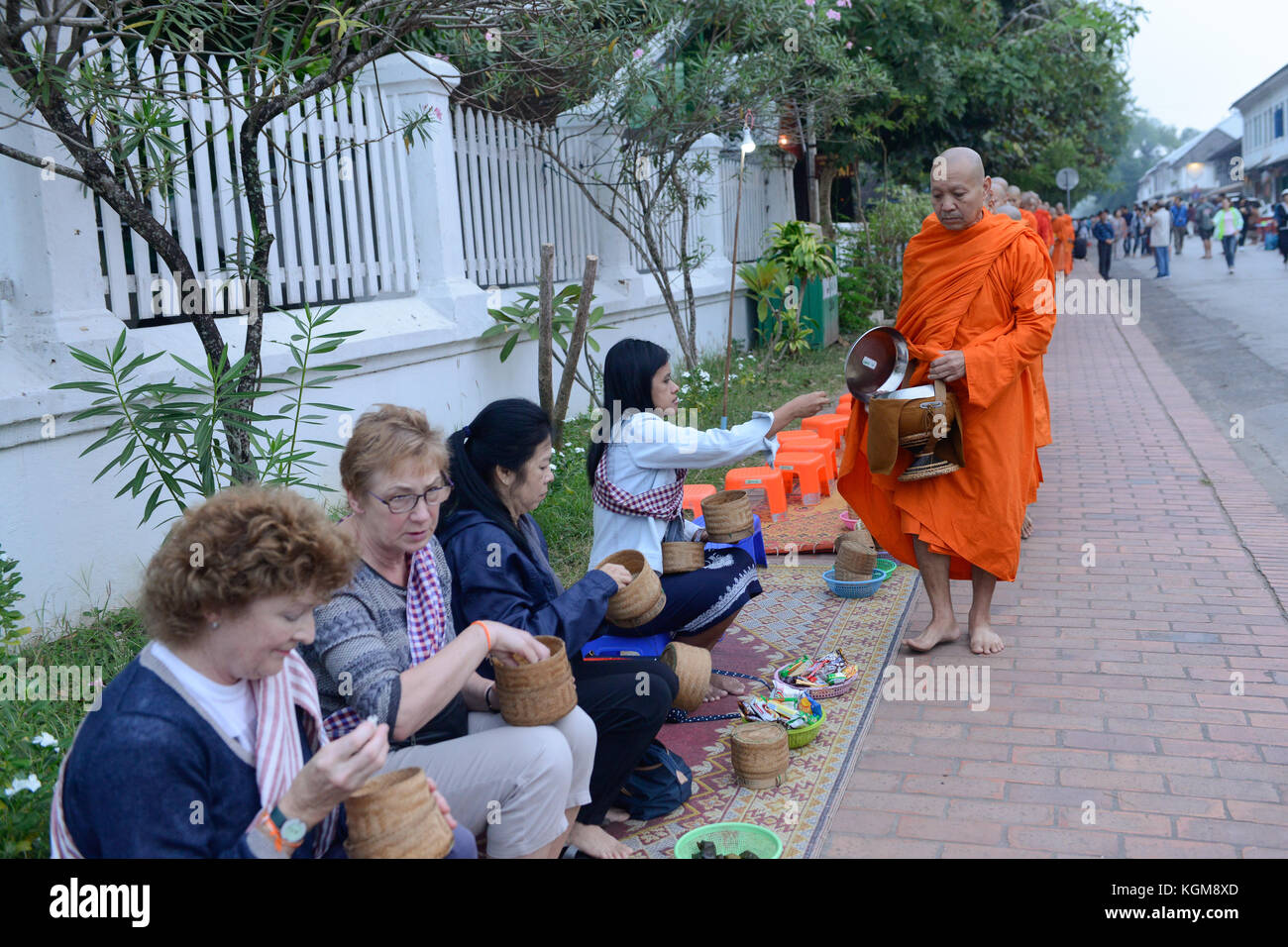 Monks going on alms round along the street in the morning of Luang ...