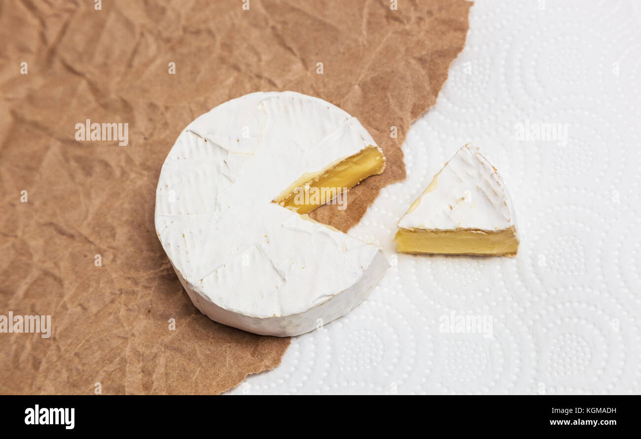 Fresh slice Camembert cheese natural, on Kraft paper brown background ...