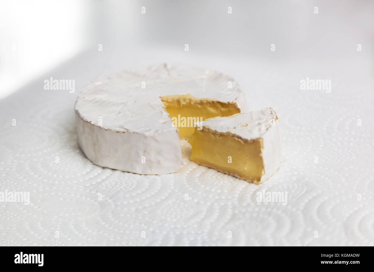 Fresh slice Camembert cheese natural, on white paper background. With ...