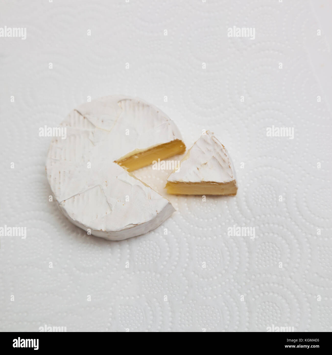 Fresh slice Camembert cheese natural, on white paper background. With ...