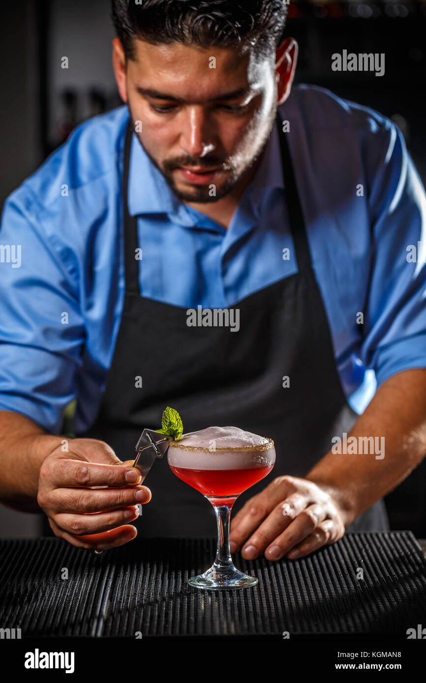 Bartender is decorating cocktail with mint leaf Stock Photo - Alamy