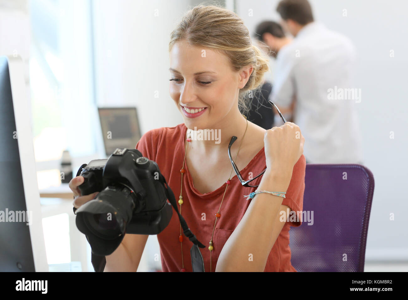 Young woman photographer working in office Stock Photo - Alamy