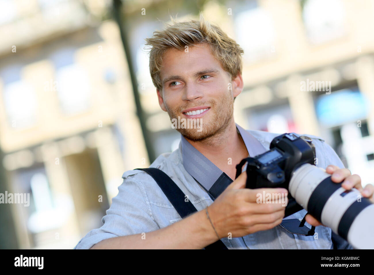 Young photographer with camera sitting on a bench Stock Photo - Alamy