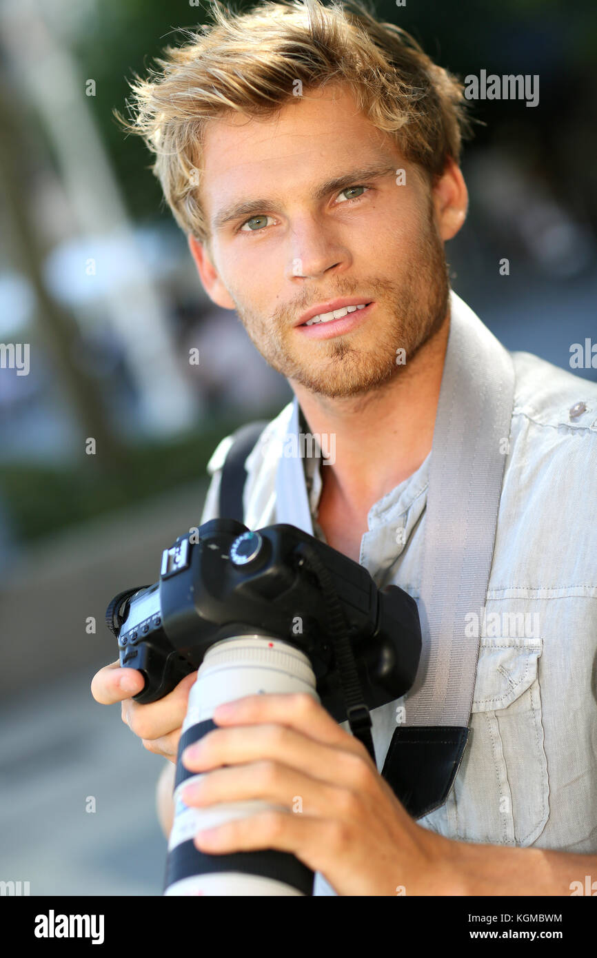 Portrait of handsome photographer holding camera Stock Photo - Alamy