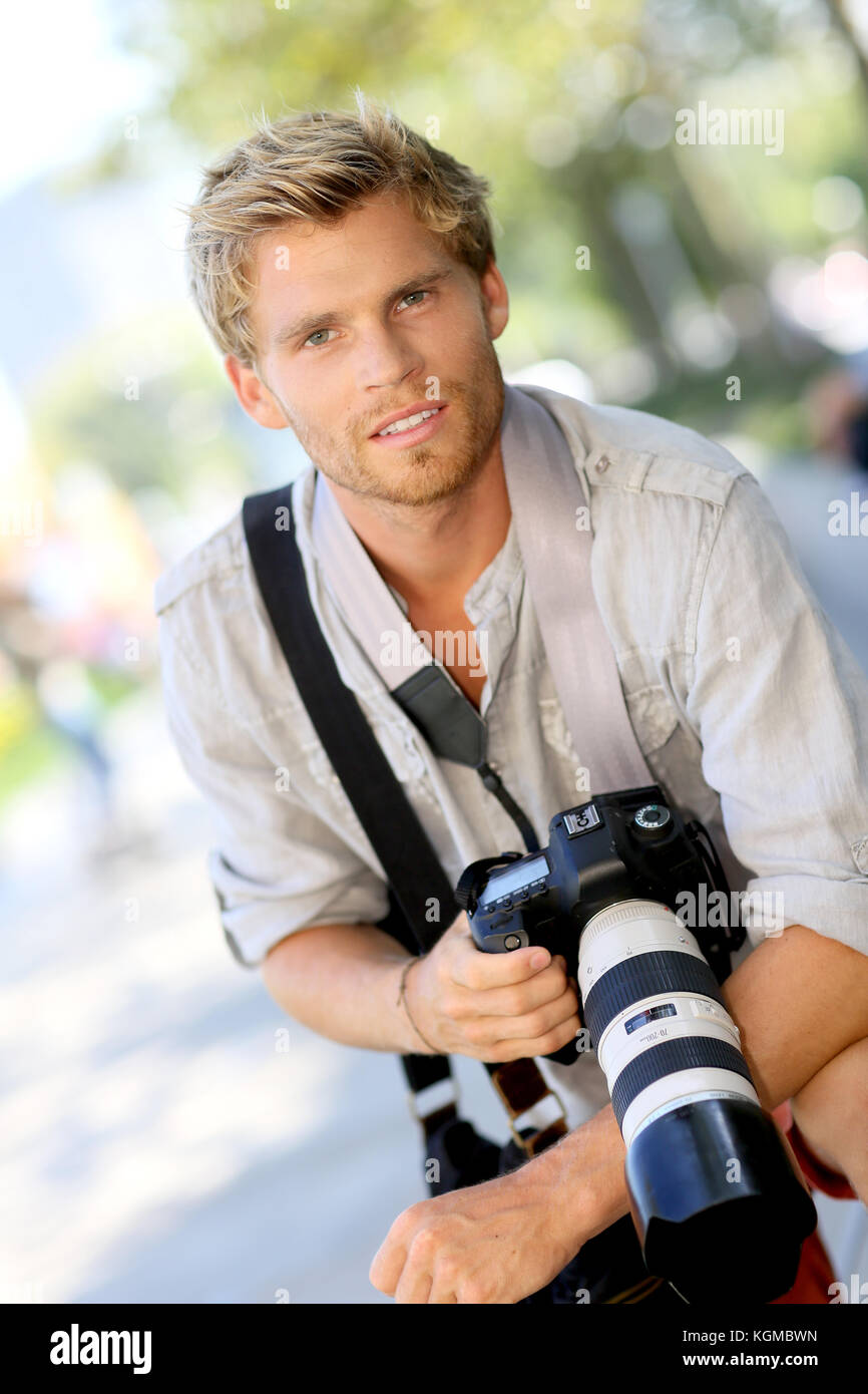 Portrait of handsome photographer holding camera Stock Photo - Alamy