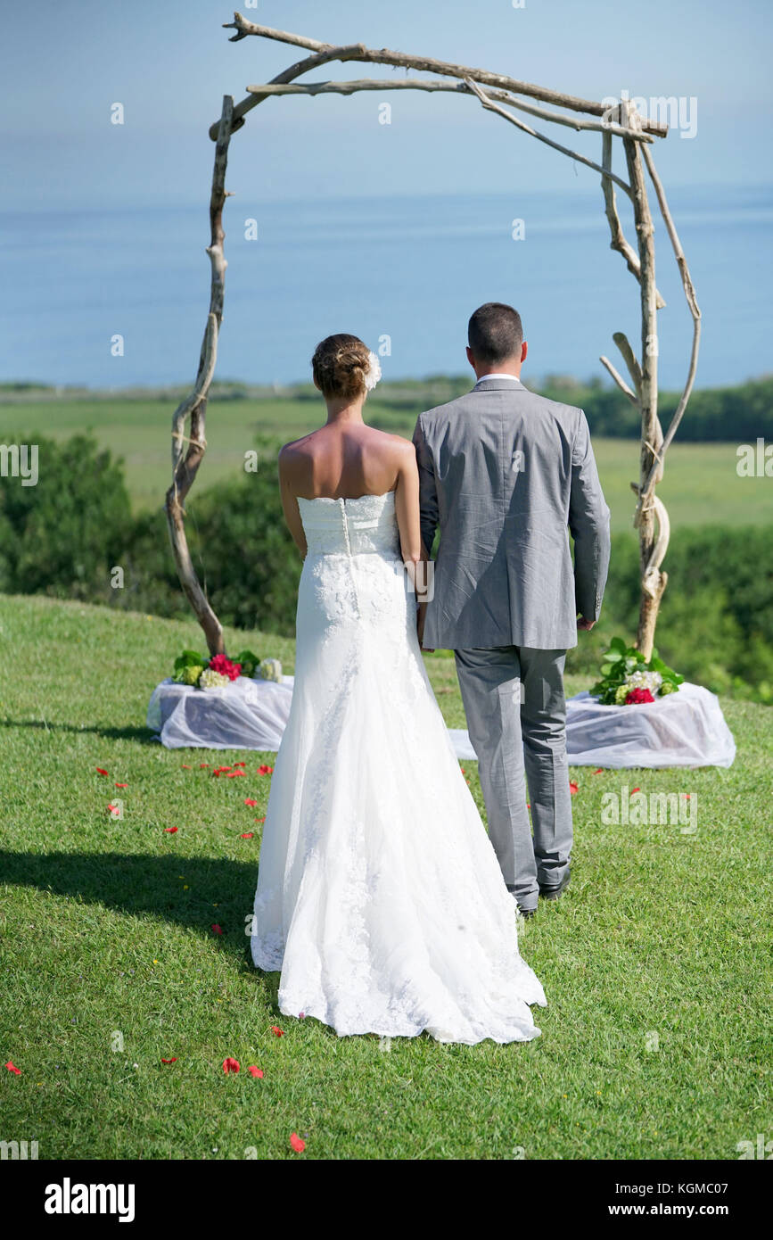 Bride and groom walking to the arch for ceremony Stock Photo - Alamy