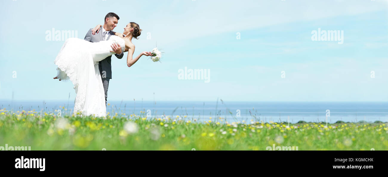 Groom carrying bride in arms hi-res stock photography and images - Alamy