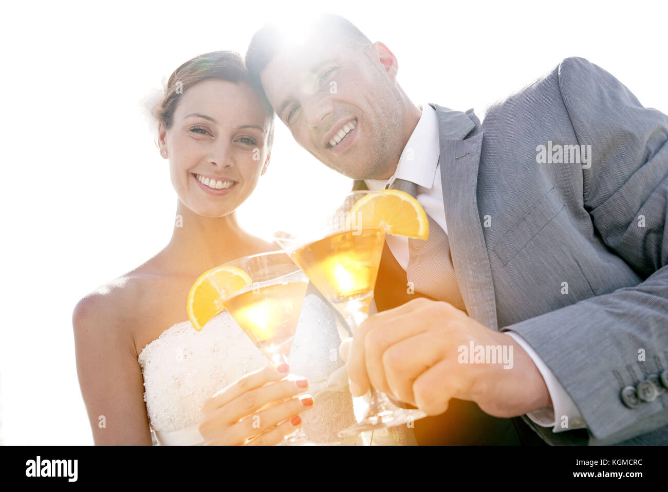 Bride and groom cheering with cocktails Stock Photo - Alamy