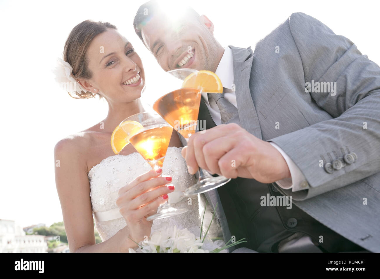 Bride and groom cheering with cocktails Stock Photo - Alamy