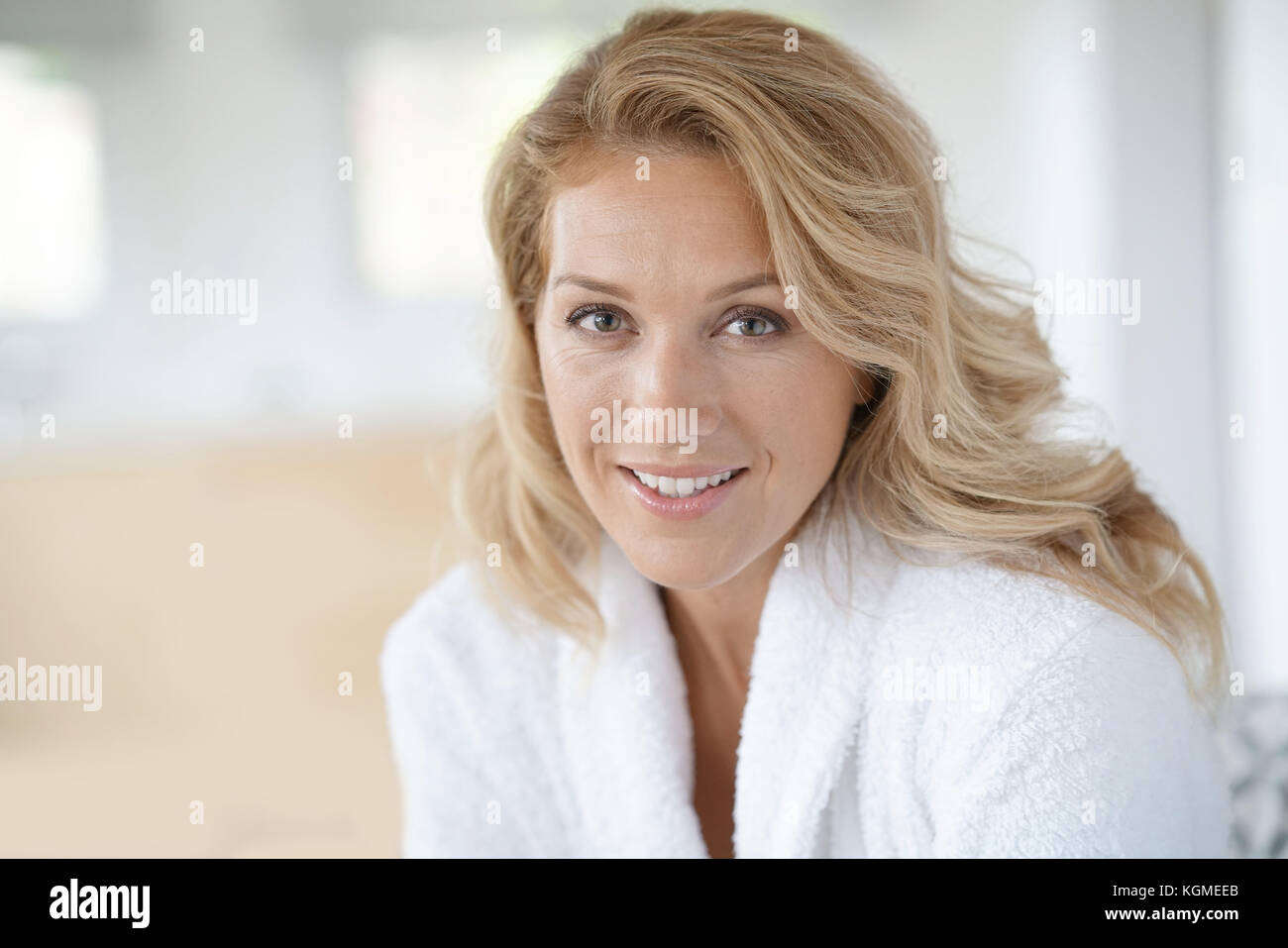 Portrait of beautiful 40-year-old woman relaxing in bathrobe at home ...