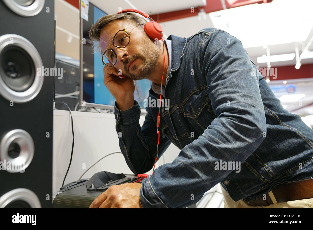 Man in multimedia store testing music with headphones Stock Photo - Alamy