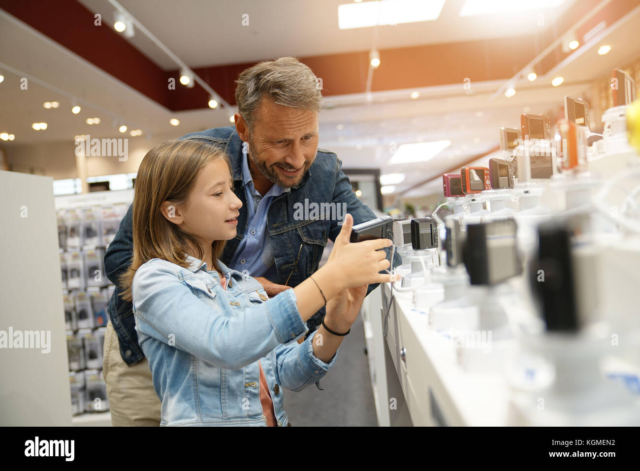 Man with kid looking at compact cameras in multimedia store Stock Photo ...