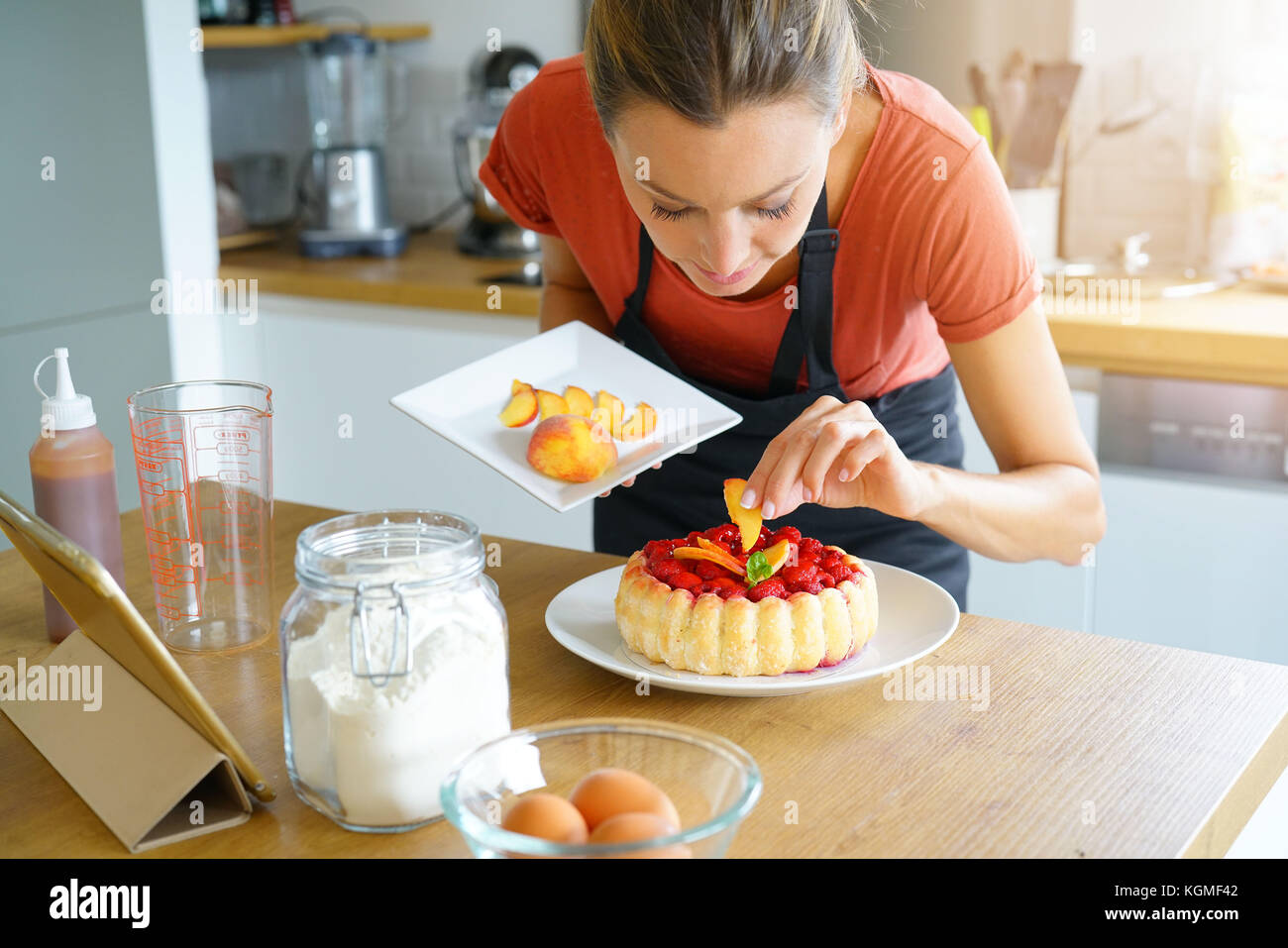 Young woman in modern kitchen baking raspberry cake Stock Photo - Alamy